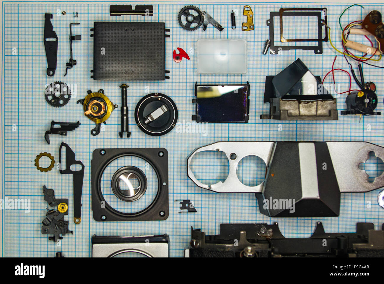 parts are completely disassembled old retro film SLR camera on graph ...