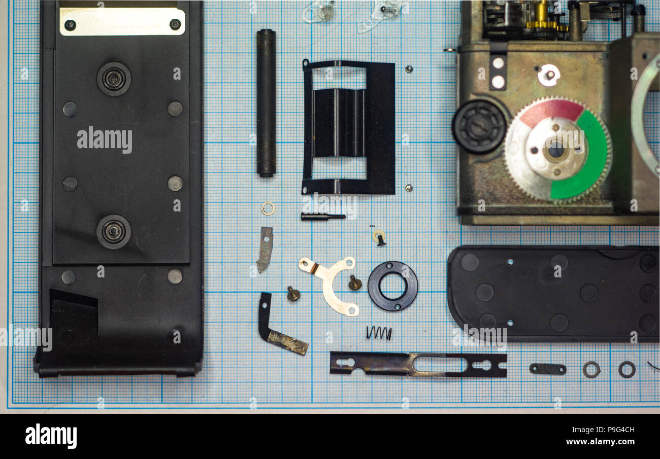 parts are completely disassembled old retro film SLR camera on graph ...