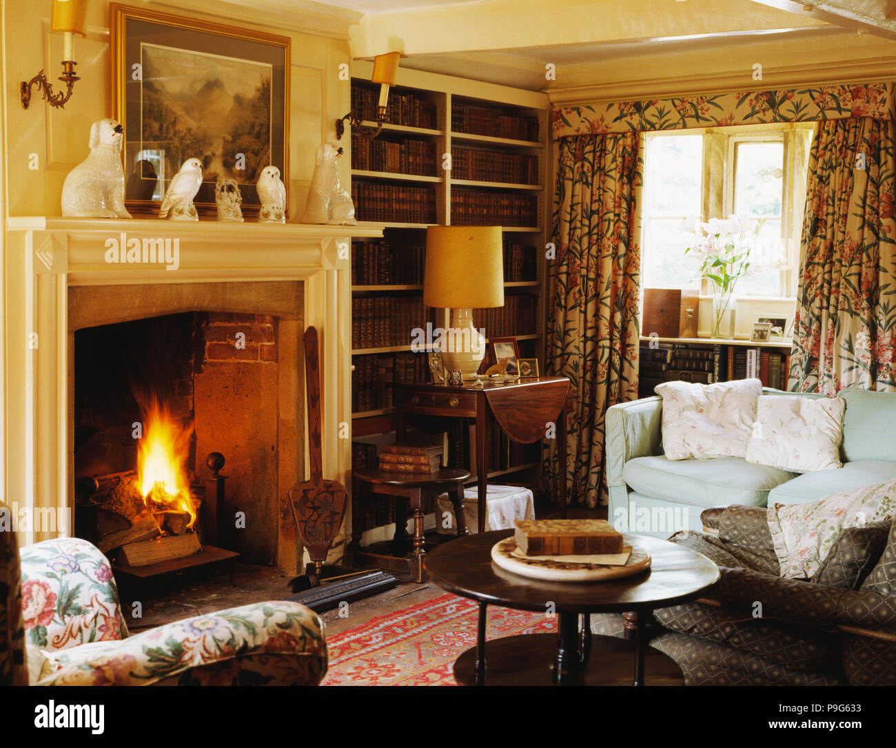 Lighted fire in fireplace in tradtional cottage living room Stock Photo ...