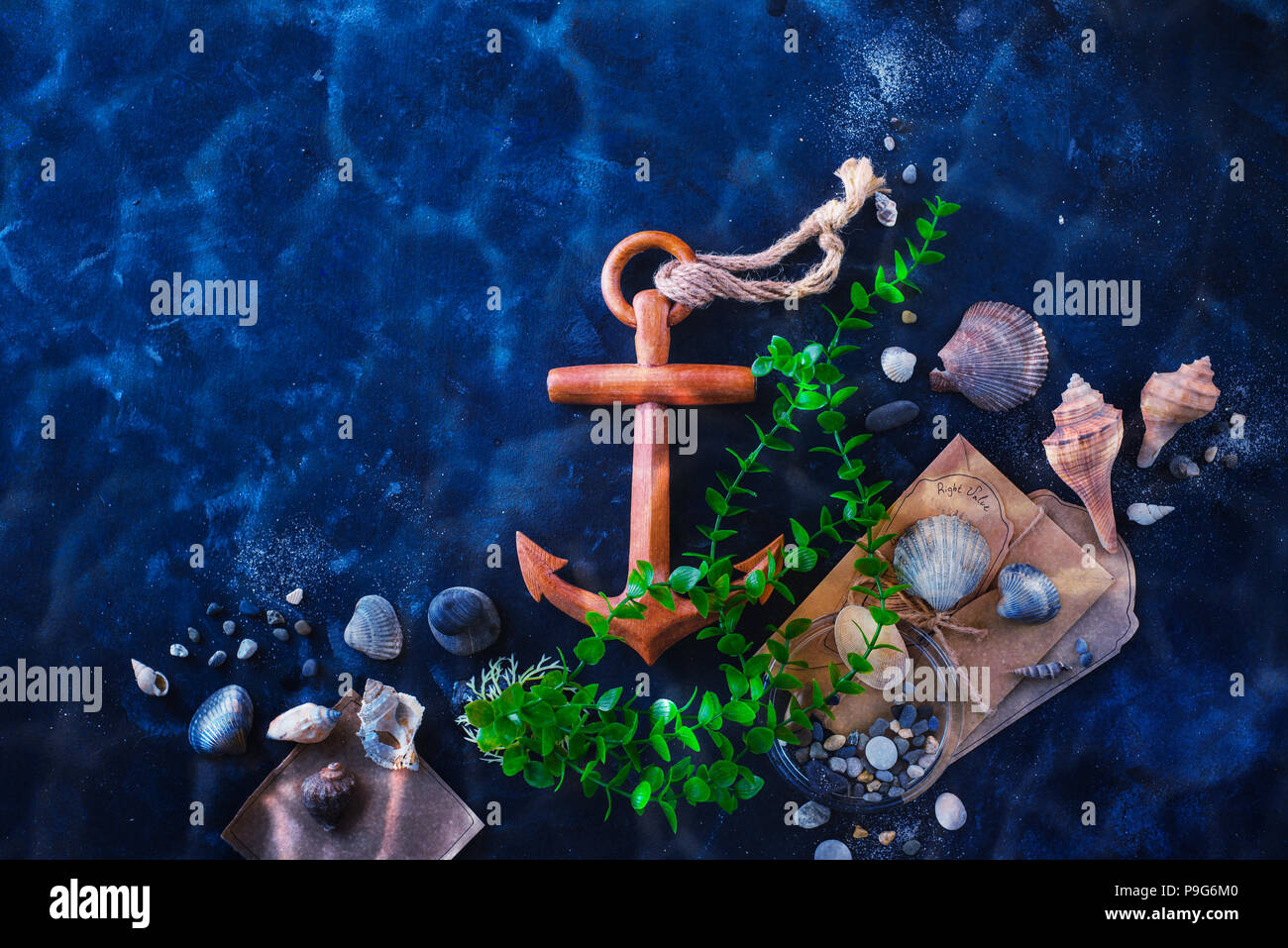 Anchor and seaweeds in an underwater still life on a dark background ...