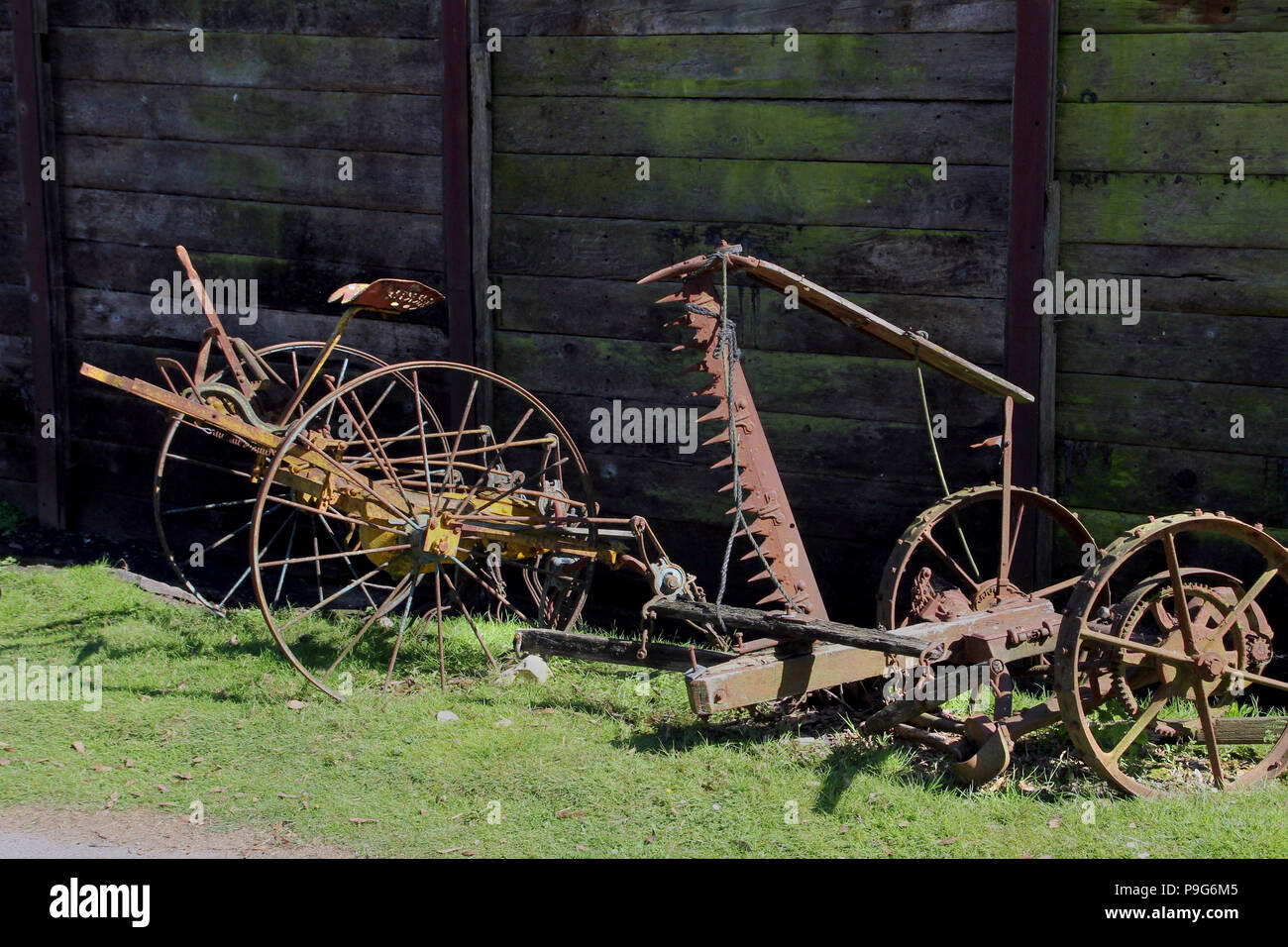 Vintage rusty old farm equipment lying unused on a grass verge in a ...