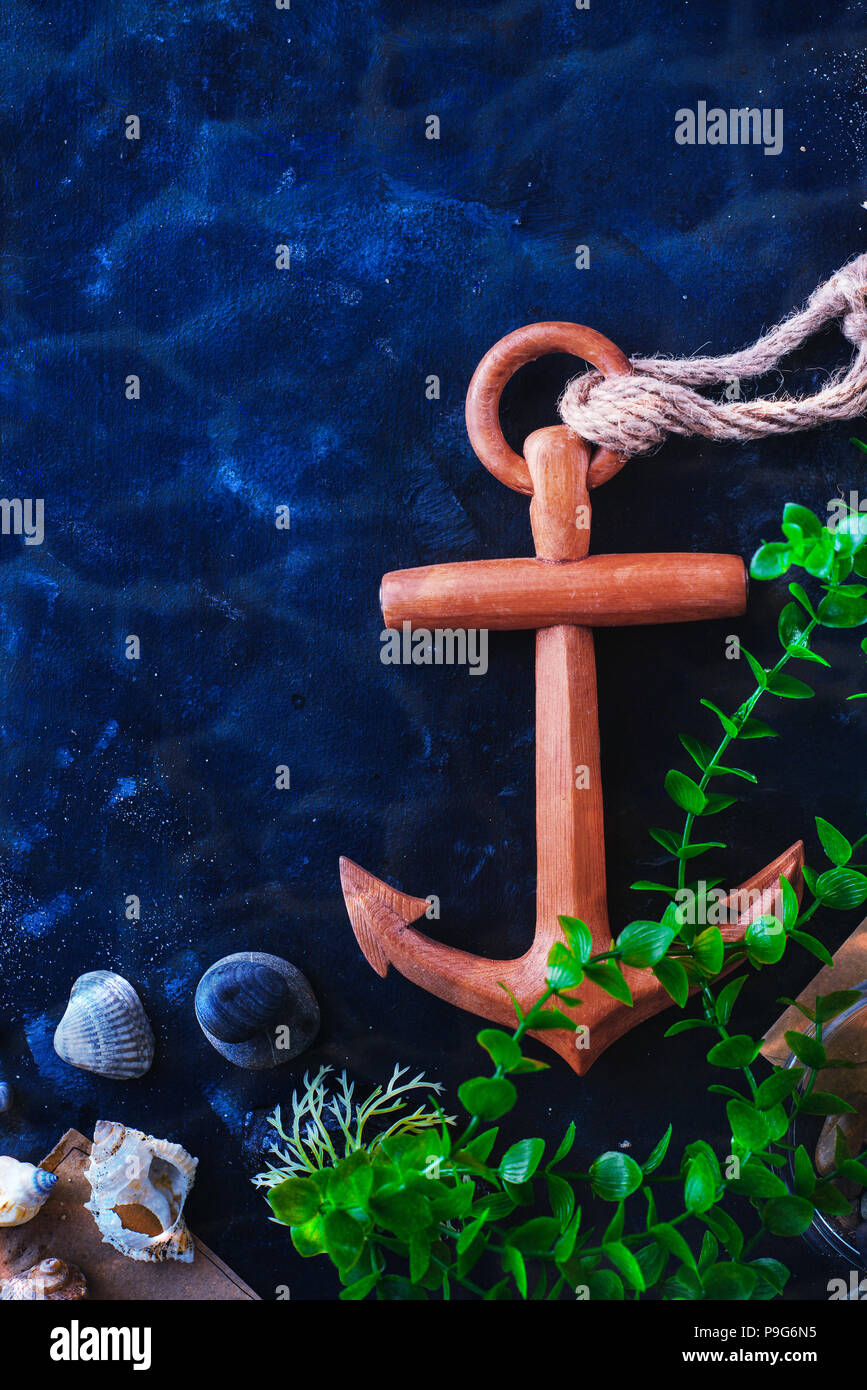 Anchor and seaweeds in an underwater still life on a dark background ...