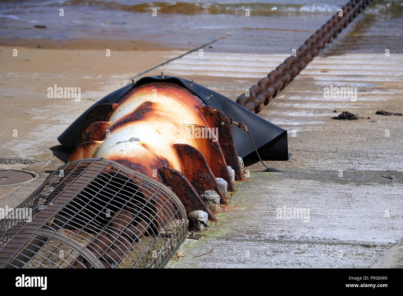 Rusty iron cover over the anchoring point of the chain used by the ...