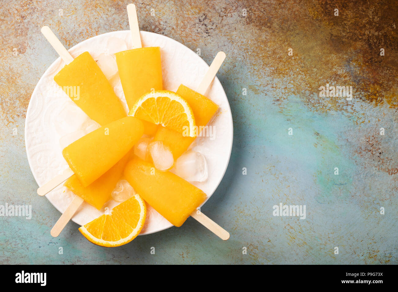 Orange popsicles with juice on a blue bacground. Ice pops, flat lay ...