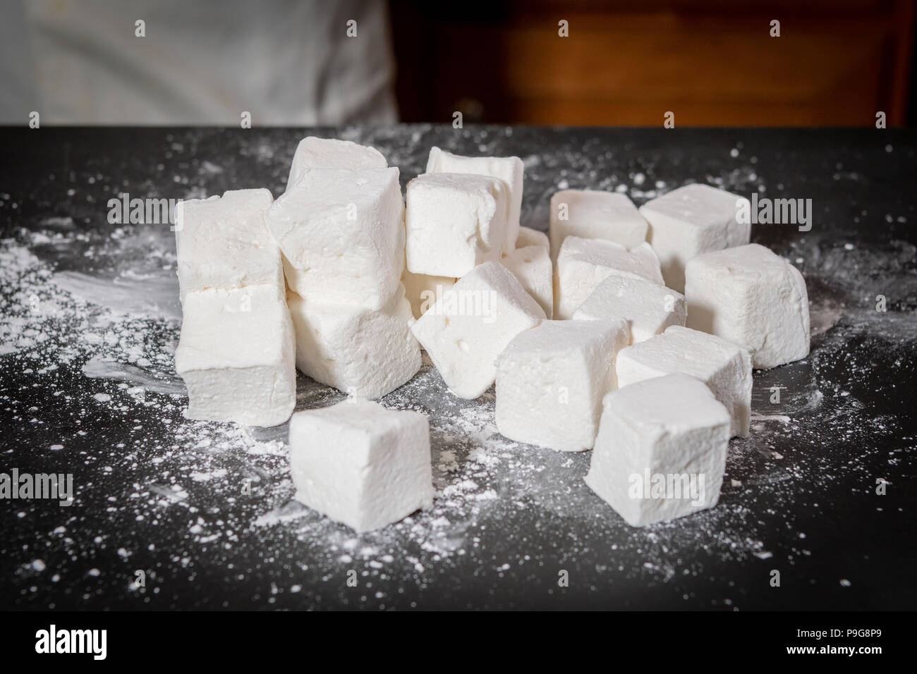 Pile of Marshmallow Cubes on sugared cutting board Stock Photo - Alamy