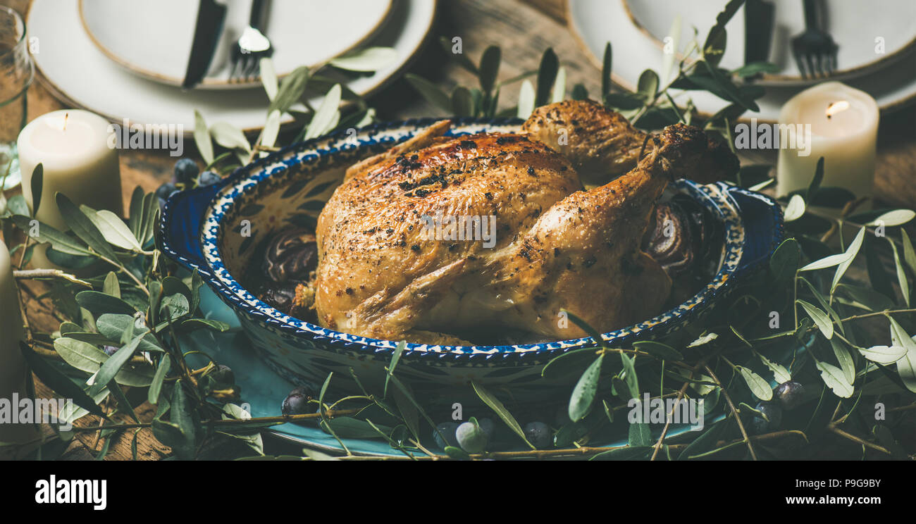 Whole roasted chicken decorated with olive tree branch, selective focus ...