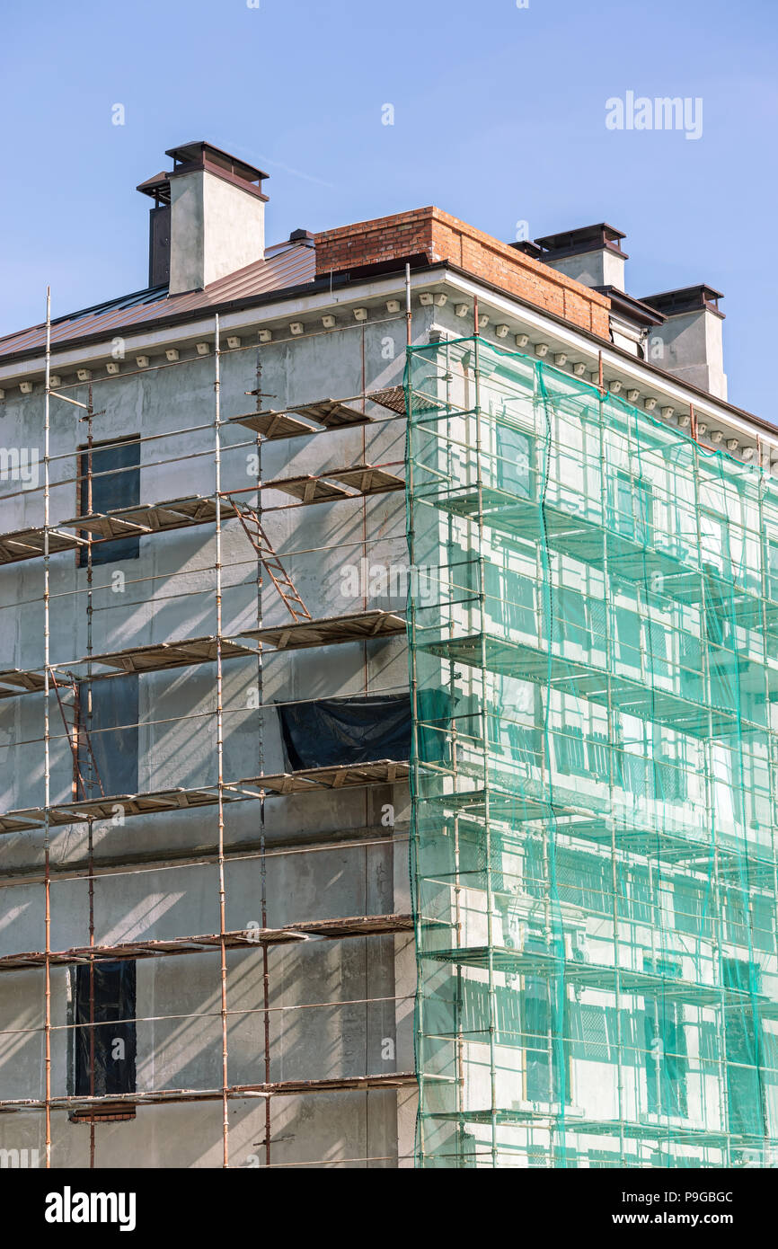 reconstruction of city building. facade with scaffolding and protective ...