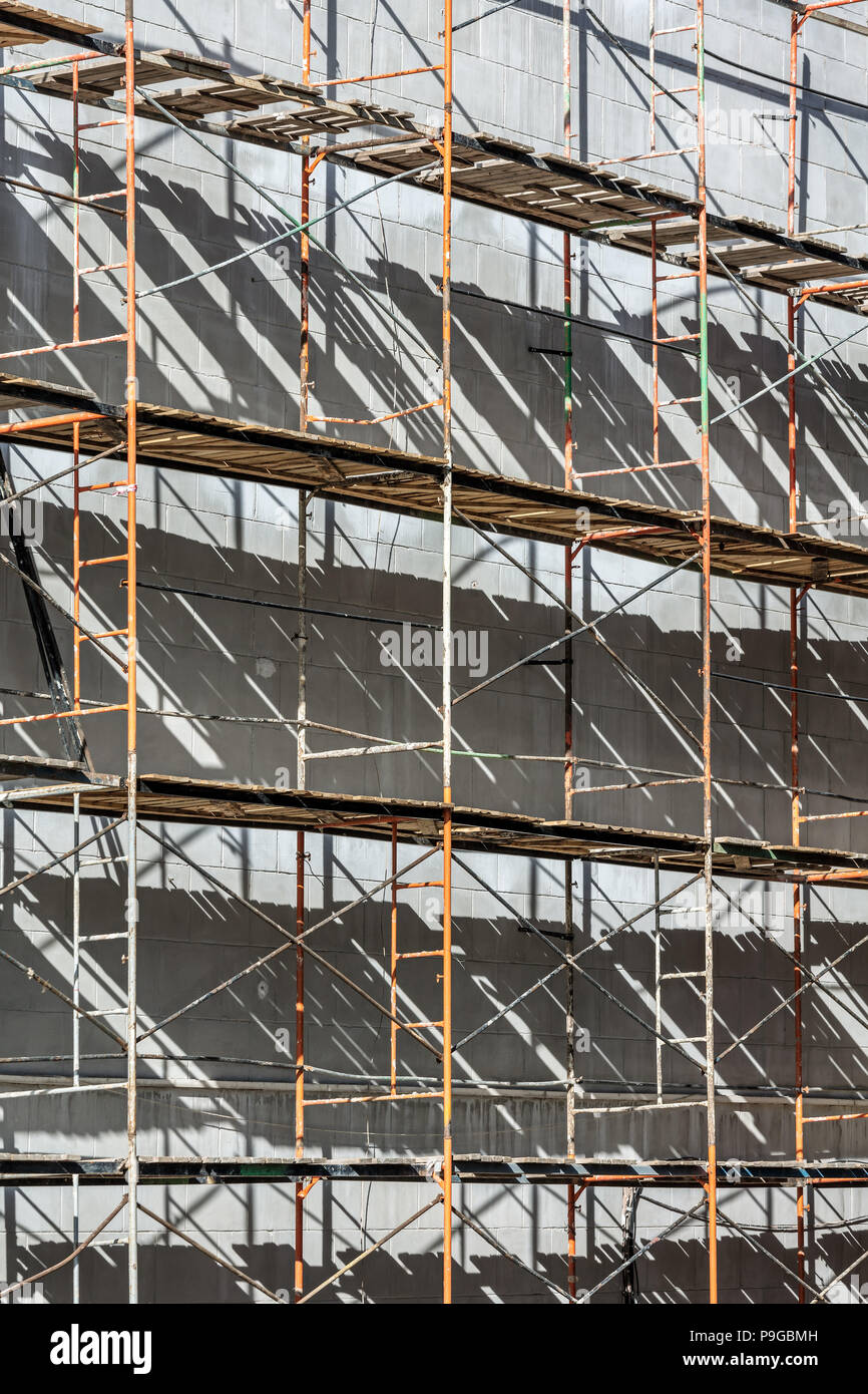 building facade with scaffolding under renovation in sunlight ...