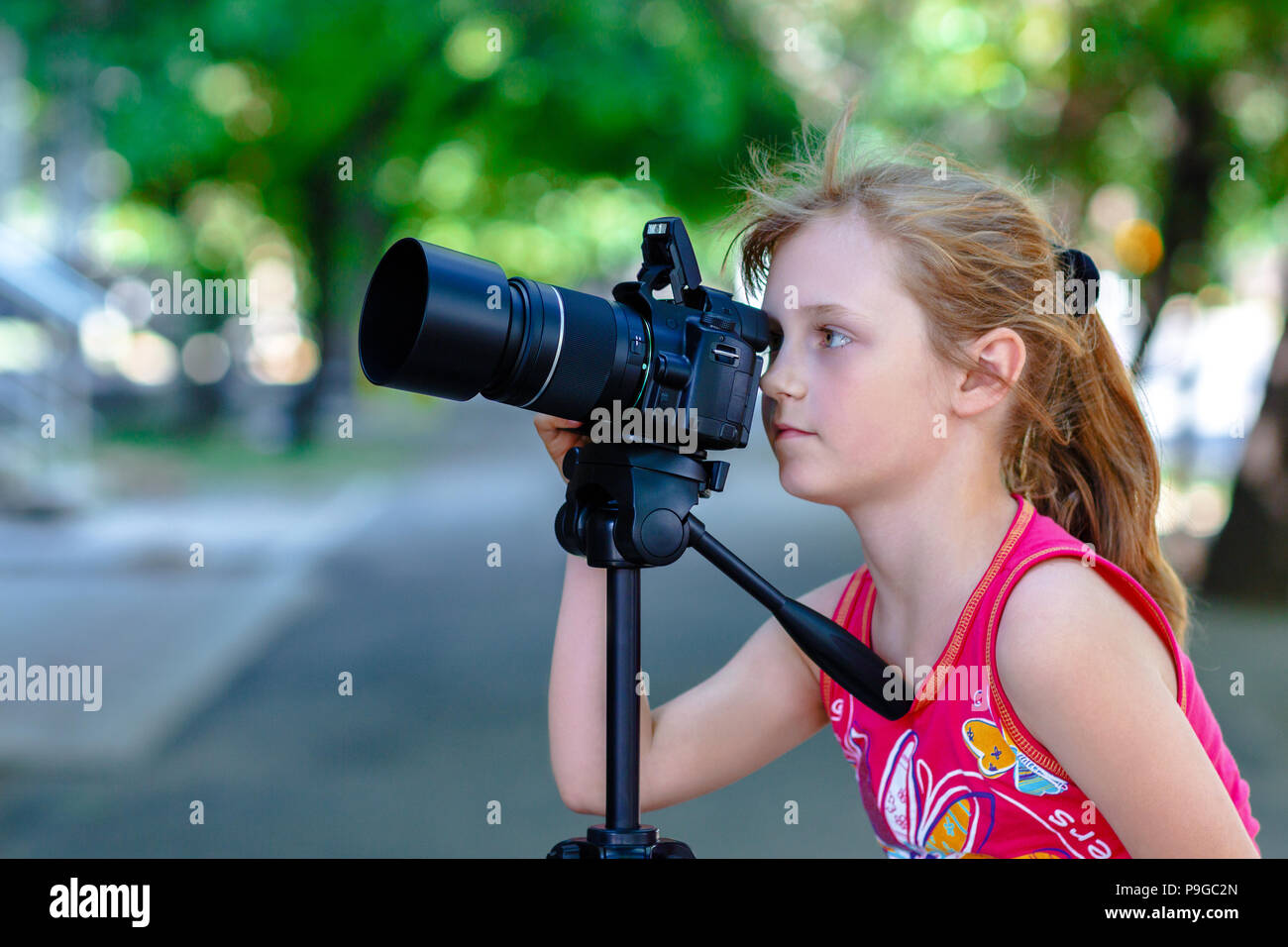 Little girl photographer looking into the camera and make the photos ...