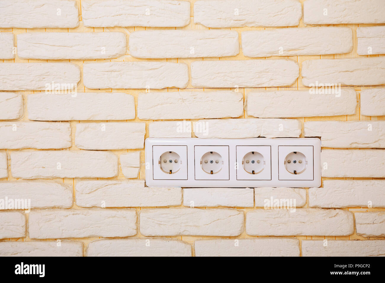 electrical outlets, four network sockets in the white brick wall, home ...