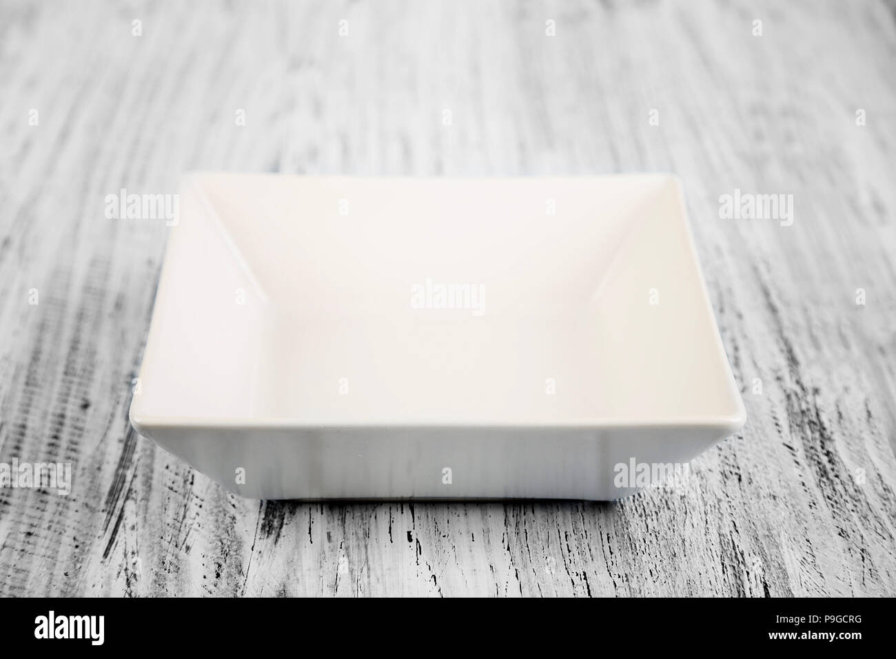 empty square plate on a wooden background Stock Photo - Alamy