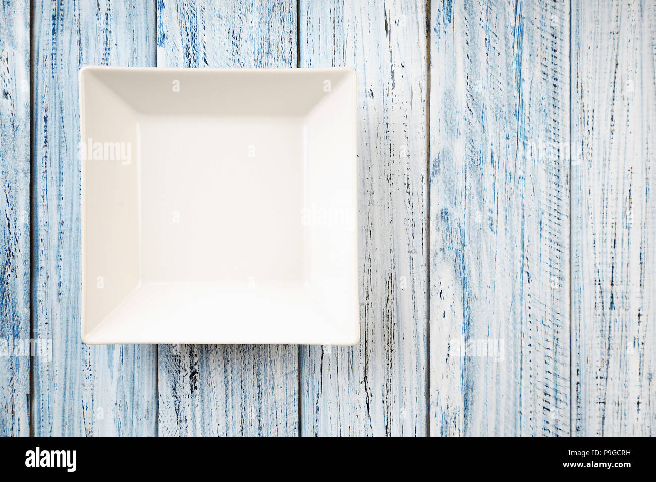 empty square plate on a wooden background Stock Photo - Alamy