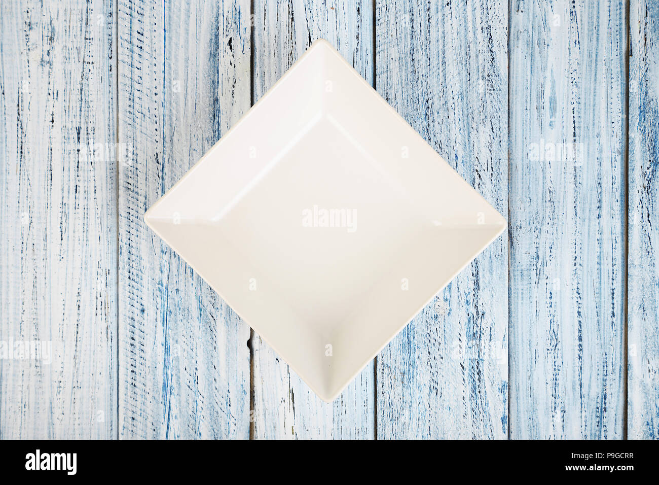 empty square plate on a wooden background Stock Photo - Alamy
