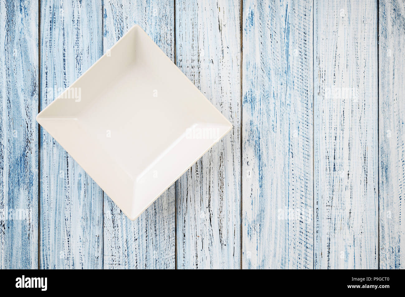 empty square plate on a wooden background Stock Photo - Alamy