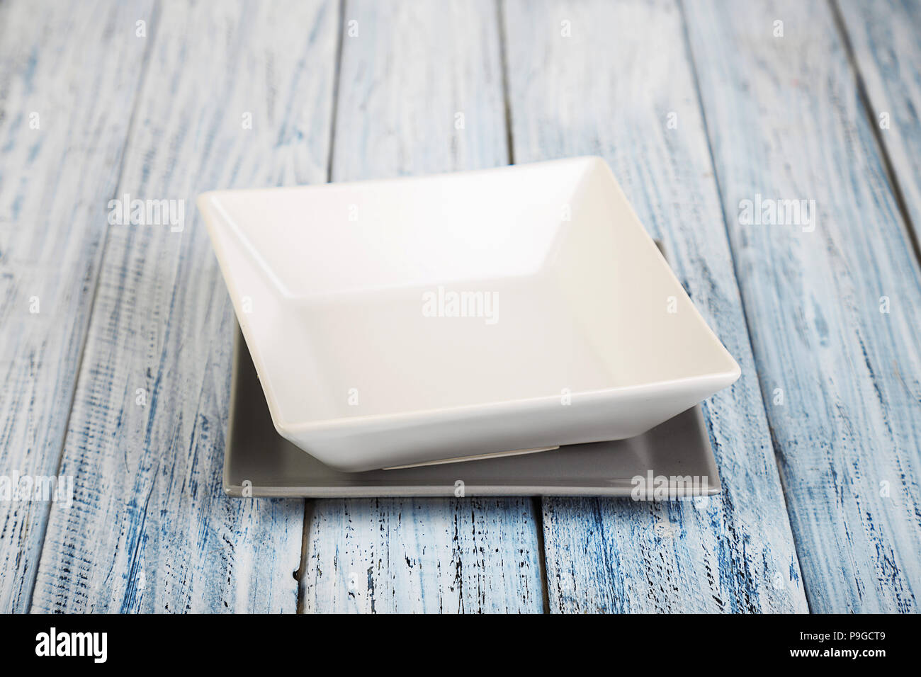 empty square plate on a wooden background Stock Photo - Alamy
