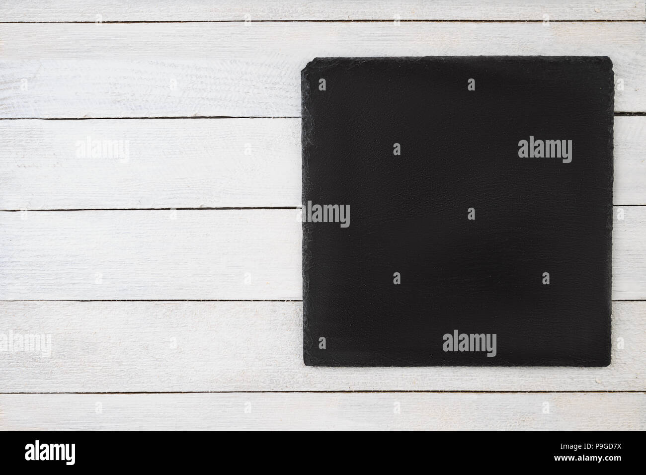 black slate board on a wooden background Stock Photo - Alamy