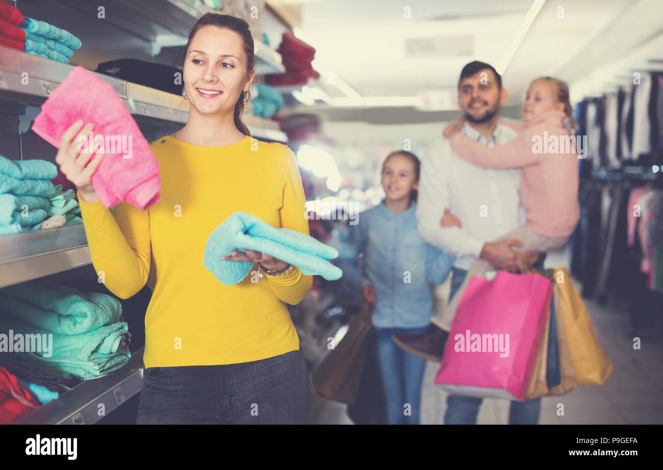 Happy cheerful positive woman looking for new terry towels during ...
