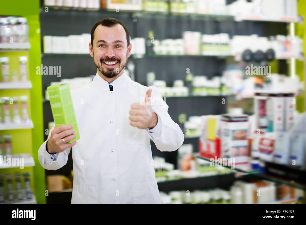 Adult man pharmacist showing assortment of drugs in pharmacy Stock ...