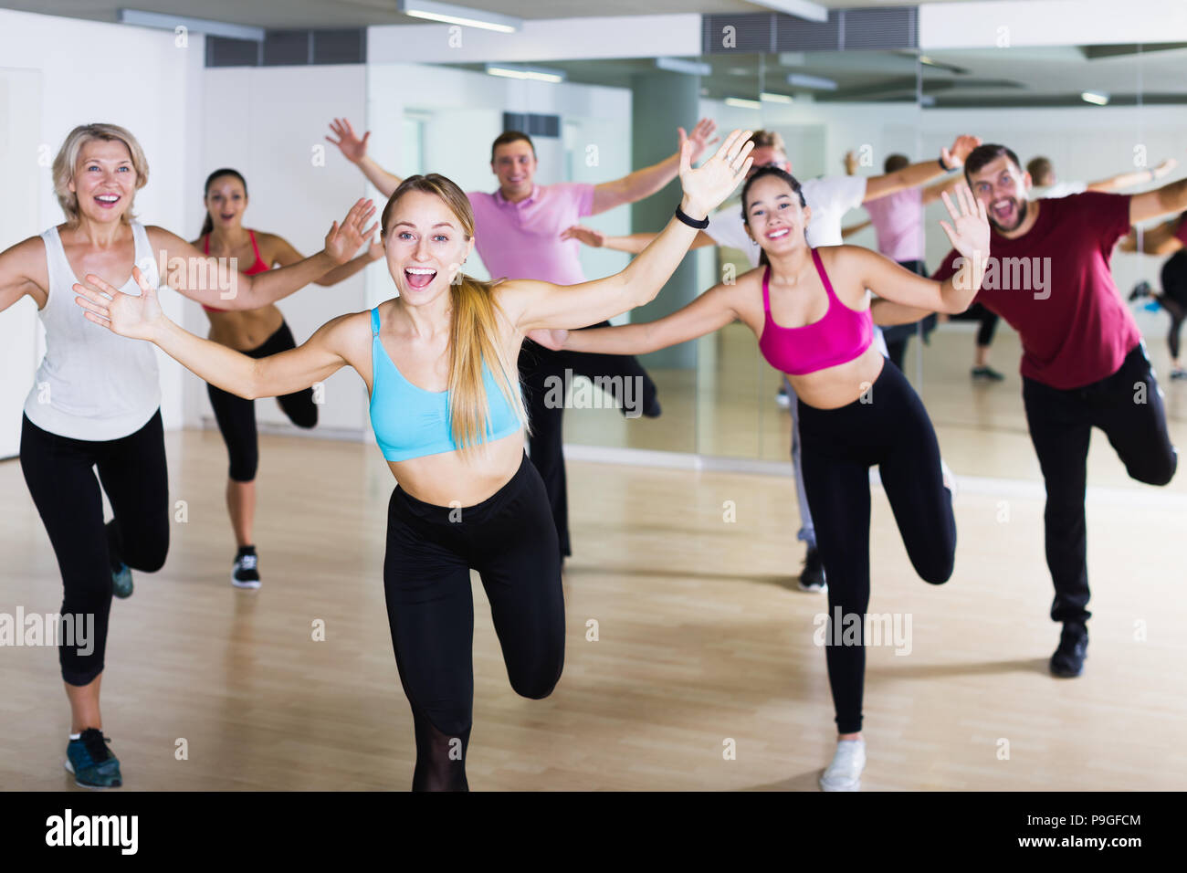Smiling people of different ages studying zumba dance elements in ...