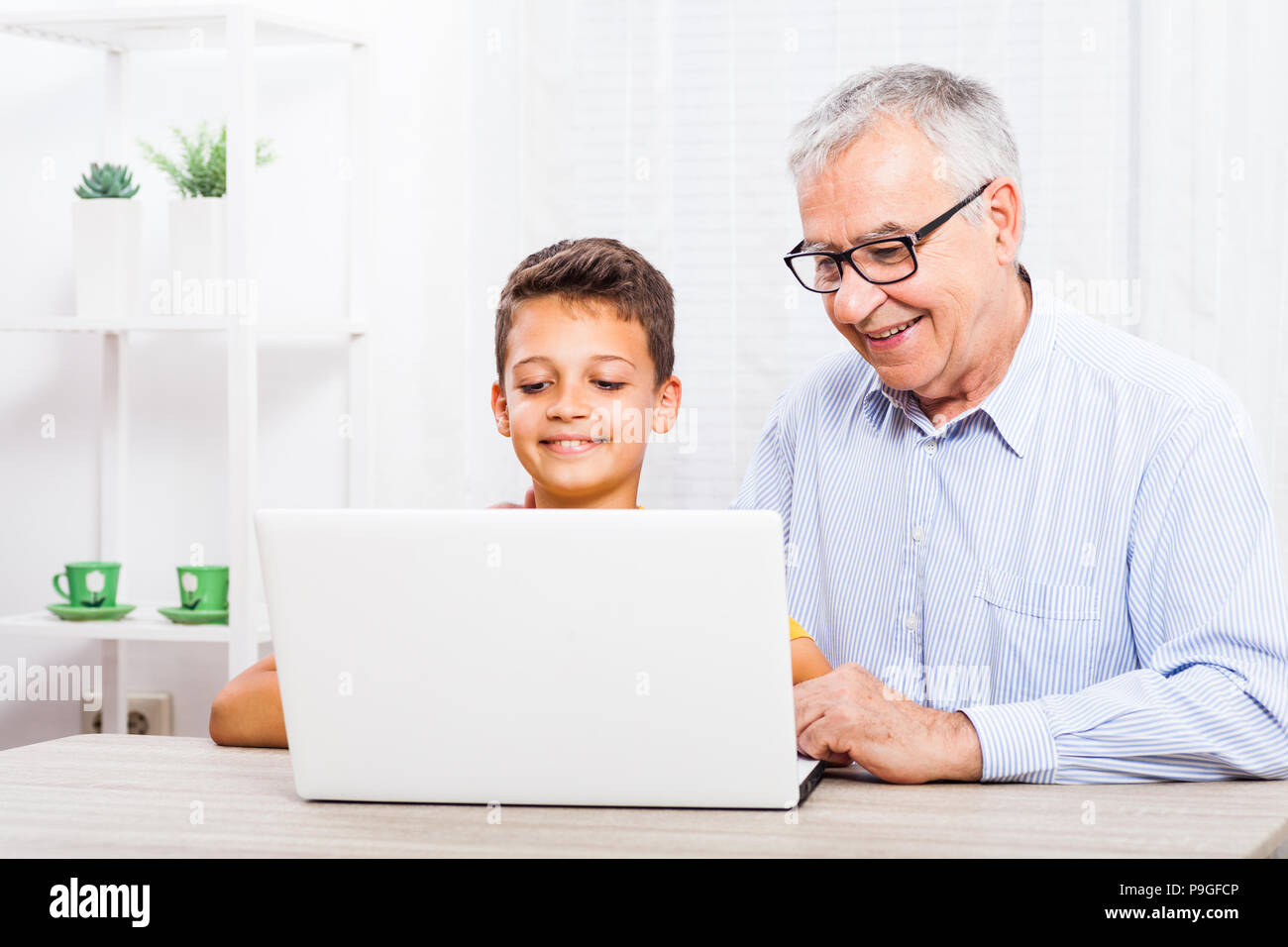 Grandfather and grandson are using laptop at home Stock Photo - Alamy