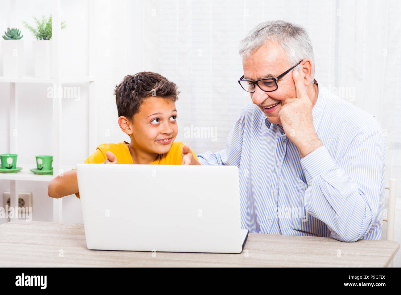 Grandson is teaching his grandfather to use laptop computer Stock Photo ...