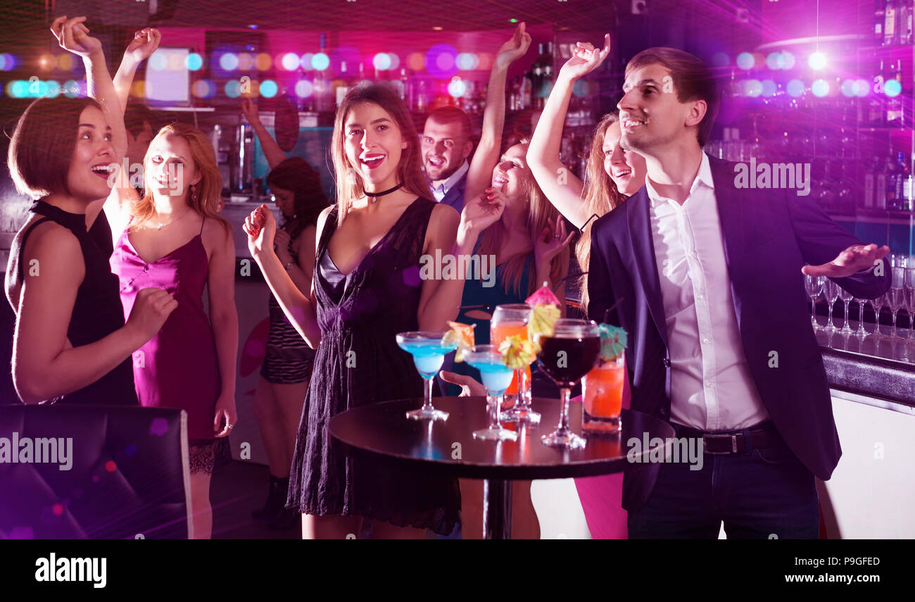 Young students dancing on university party with cocktails in the club ...