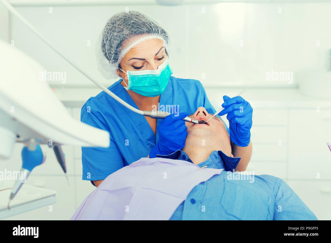 adult dentist checking teeth of patient male sitting in medical center ...