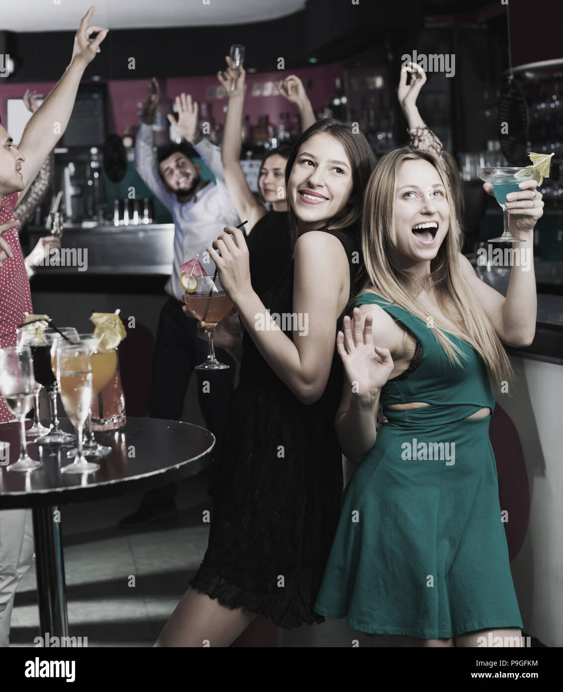 Portrait of cheerful females and males having fun in the bar Stock ...