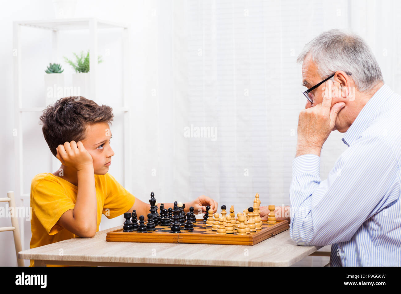 Grandfather and grandson are playing chess at home Stock Photo - Alamy