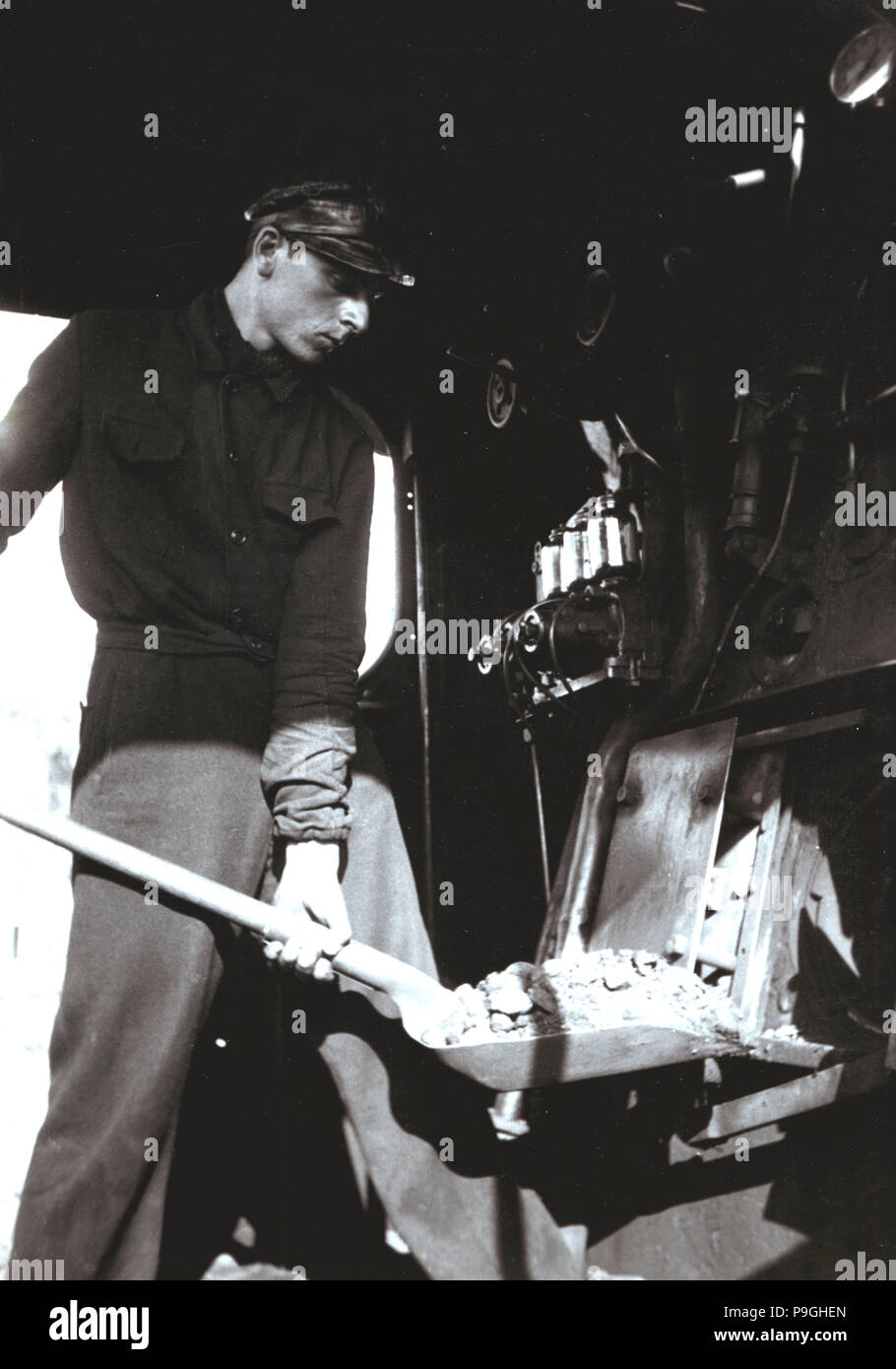 Stoker putting coal to a steam train engine Stock Photo - Alamy