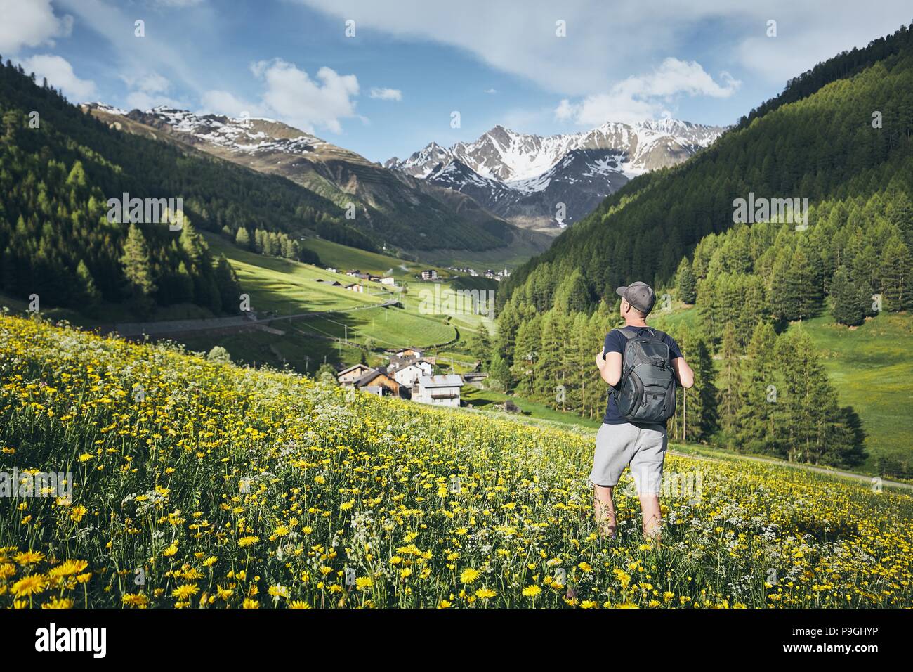 Young man (tourist) with backpack in nature. Village in mountains ...