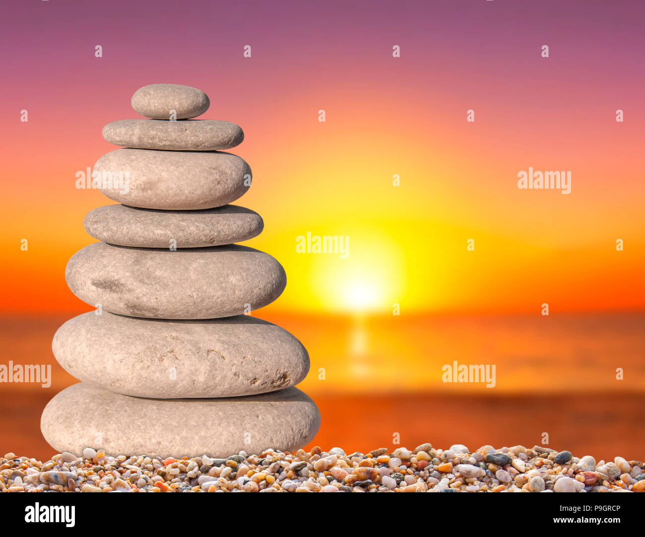 Small beach zen stone with sun down background close up for spa and ...