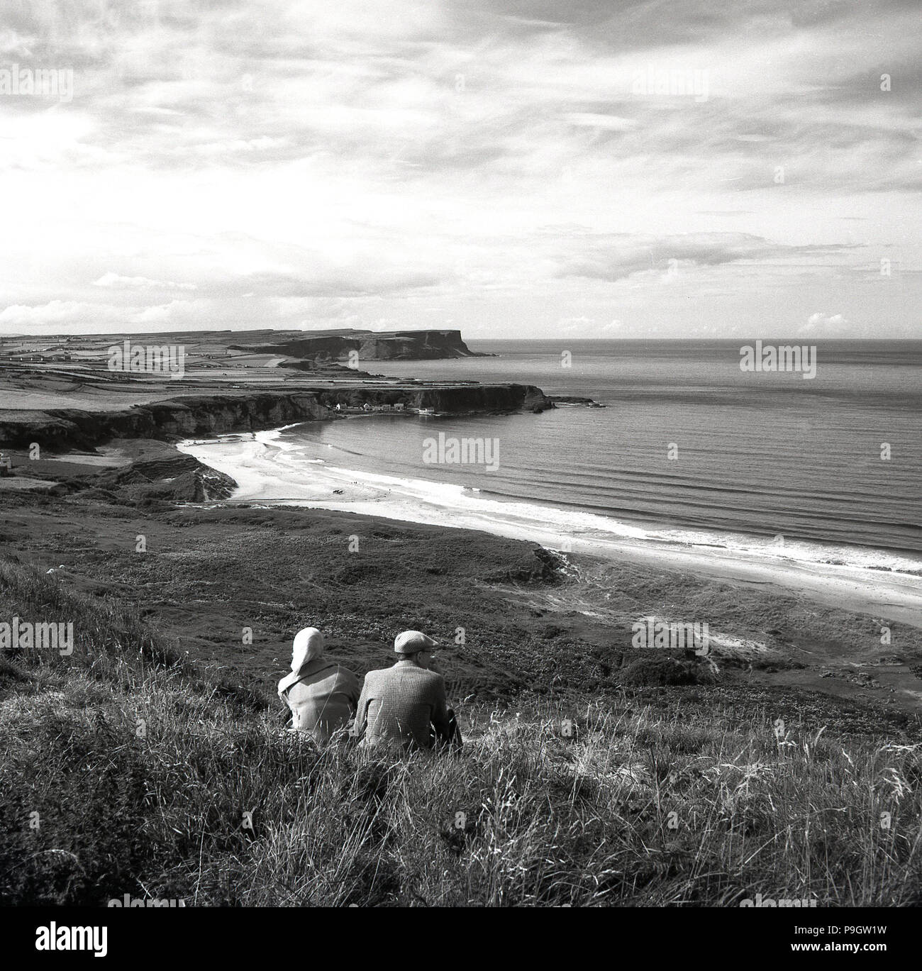 1950s, historcial, a man and woman sitting together on a hillside ...