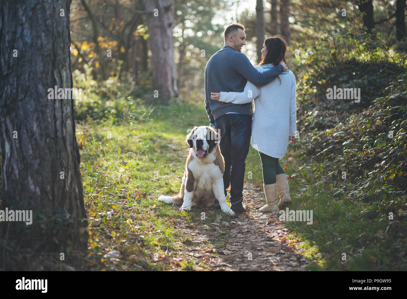 People and dogs. Young couple enjoying nature outdoors together with ...