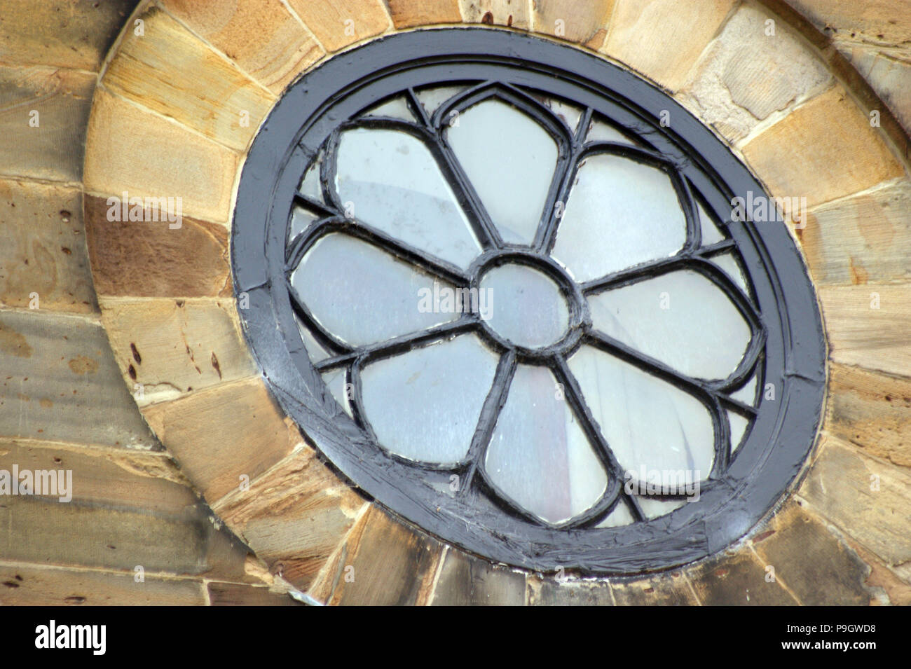 Circular Old Leaded Small Rose Window inset on the Exterior Stone Wall ...