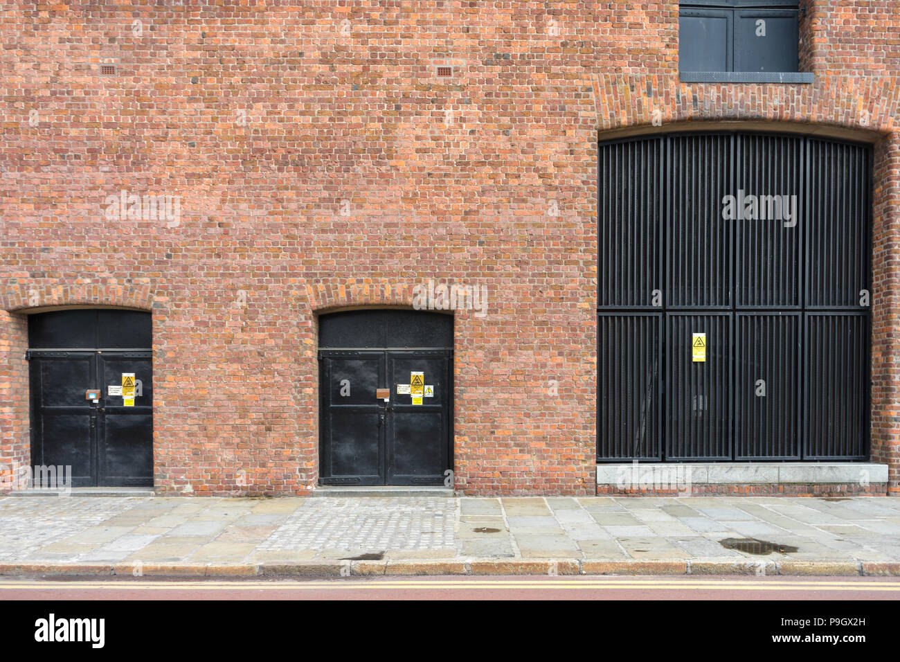 Doors at the Albert Dock, Liverpool - Red brick wall with black door ...