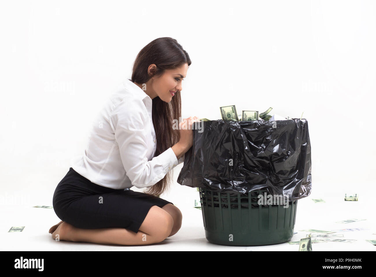 Beautiful lady sitting next to trash can looking down in it. Woman ...