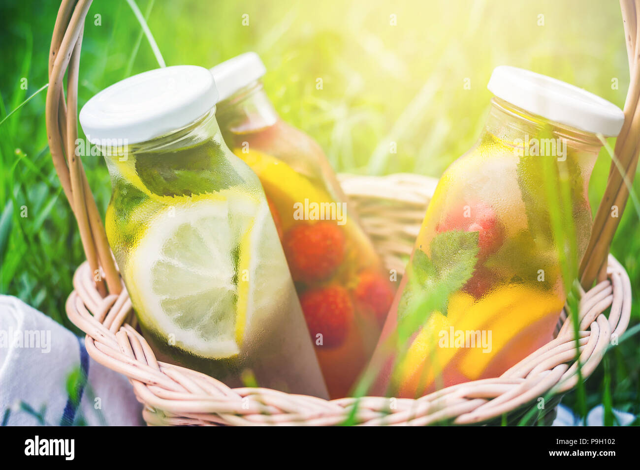 Selection of summer lemonades. Basket on the meadow with refreshing ...