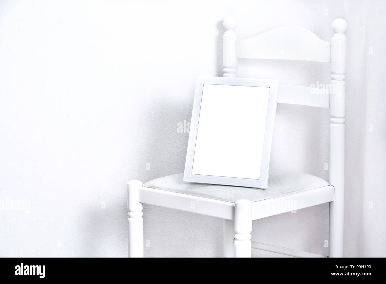 White frame on chair on white background. Mock up Stock Photo - Alamy