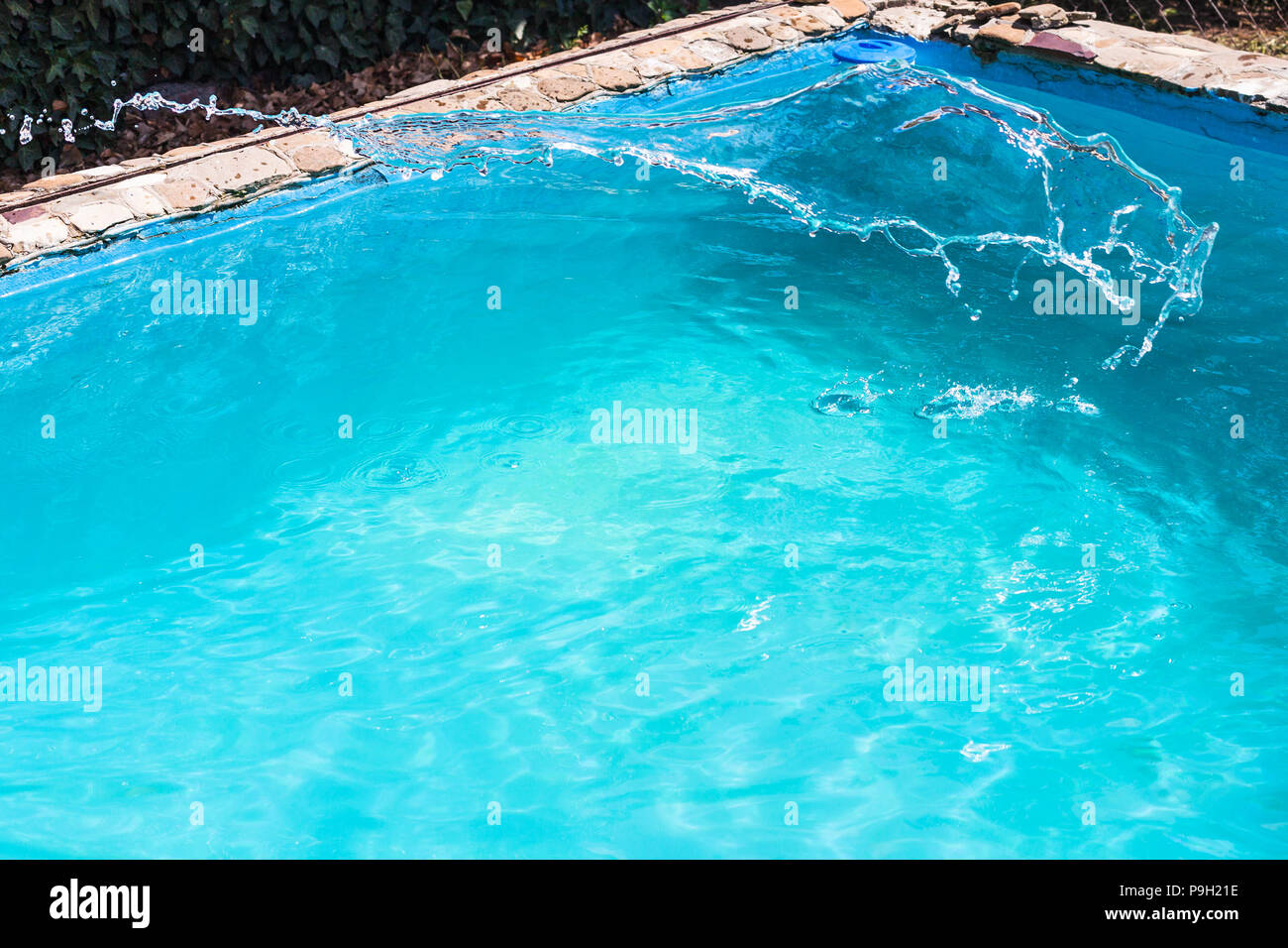 splashing of disinfectant in outdoor swimming pool on backyard of ...