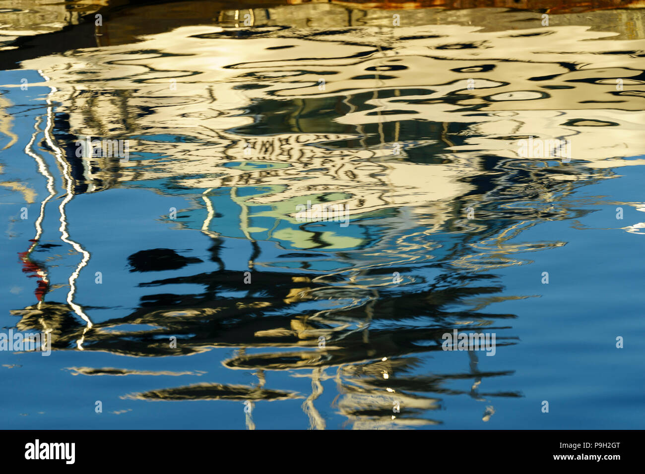 An abstract photograph of the shimmering reflections of a boat on the ...