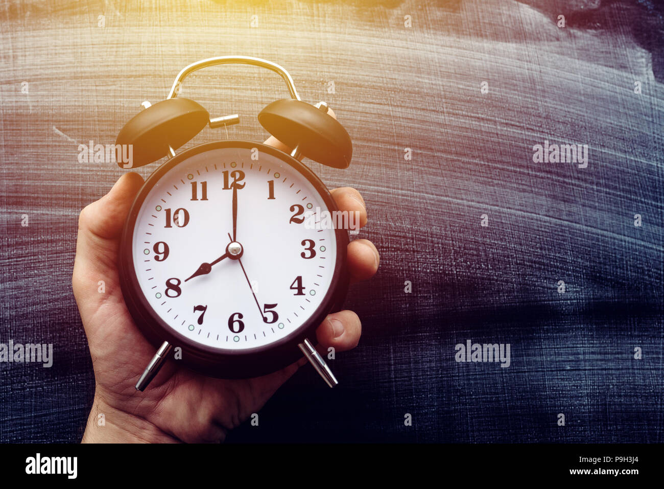 Eight o'clock in the morning, time for school. Teacher holding classic ... Eight o'clock in the morning, time for school. Teacher holding classic ...