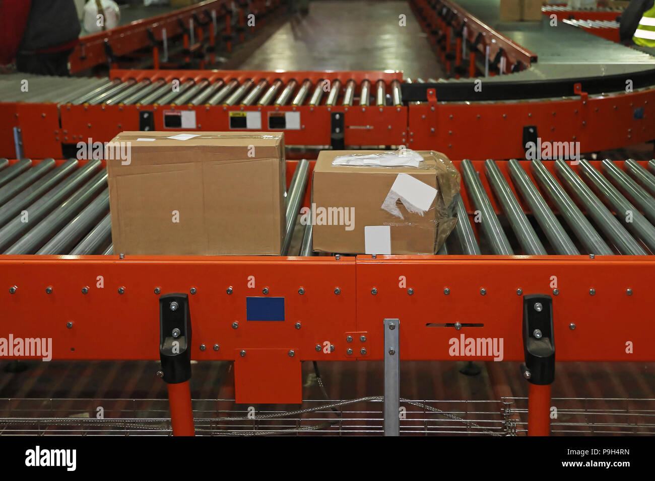 Shipping boxes at conveyer belt in distribution warehouse Stock Photo ...