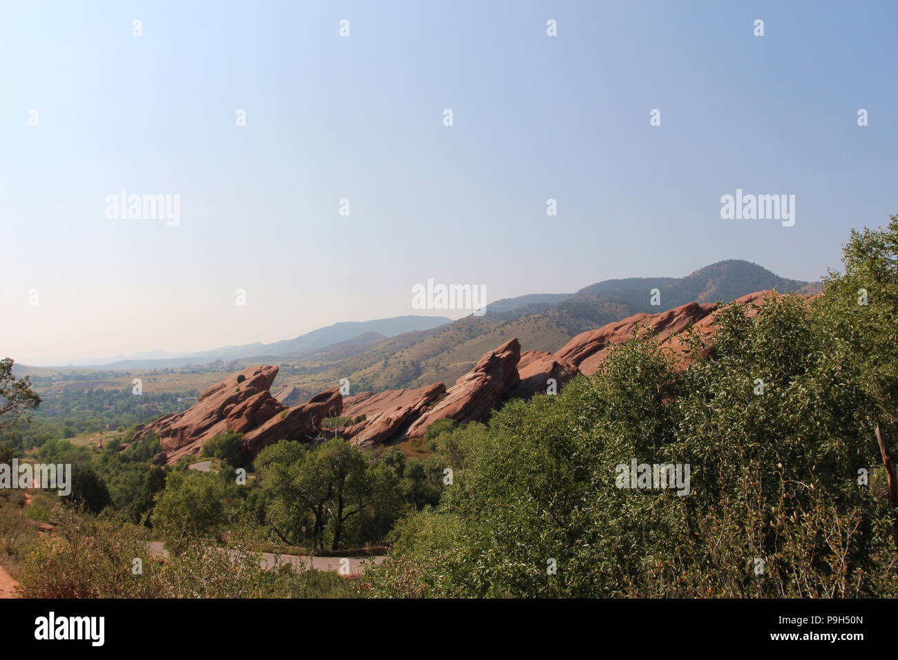 Large red rock formations, jutting out of the ground behind Red Rock ...