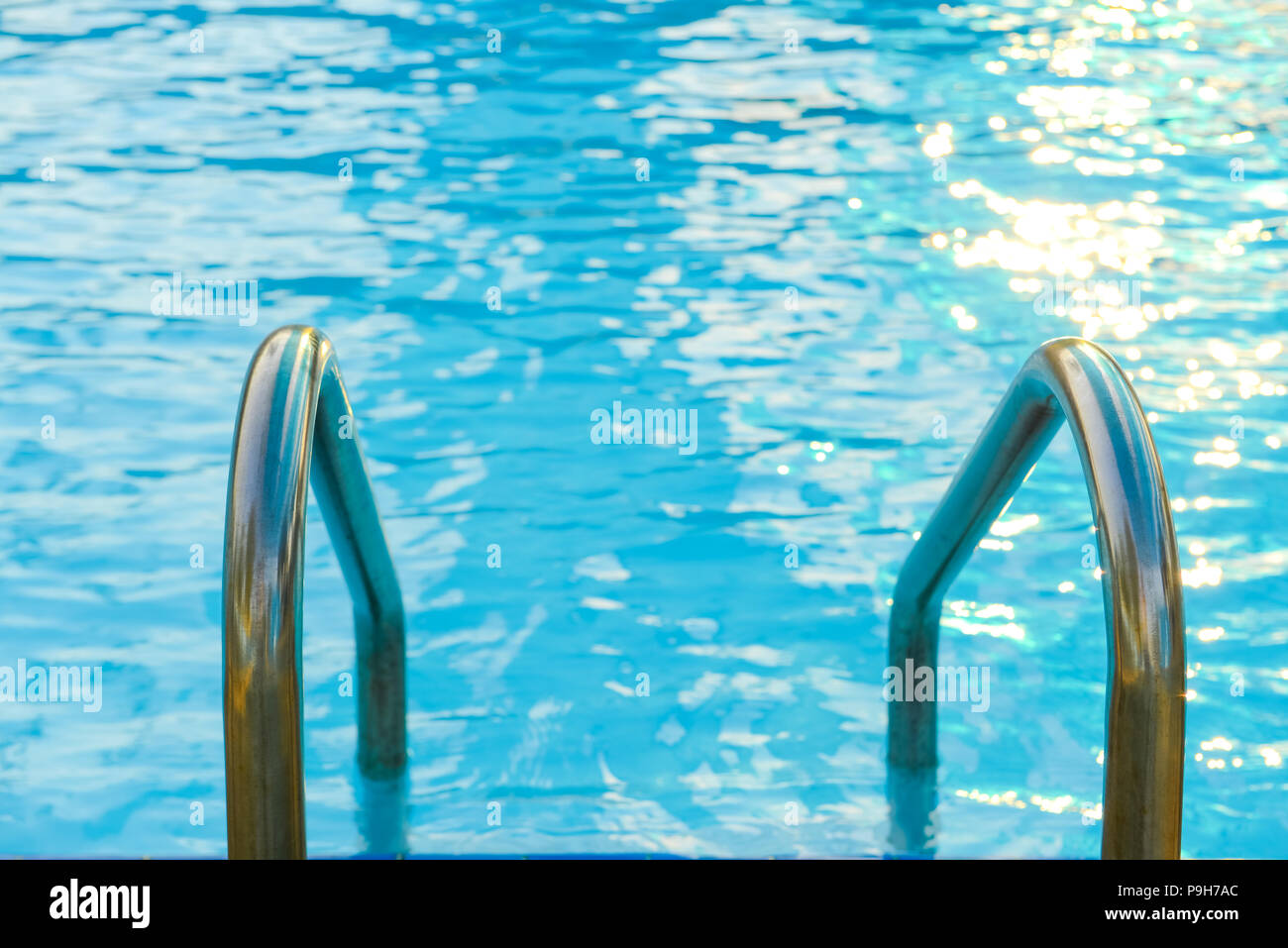 Grab bars ladder in the blue swimming pool Stock Photo - Alamy