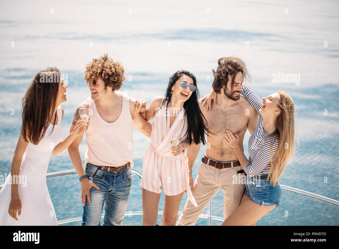 Two rich guys having Yacht party with beautiful ladies on sailing boat ...