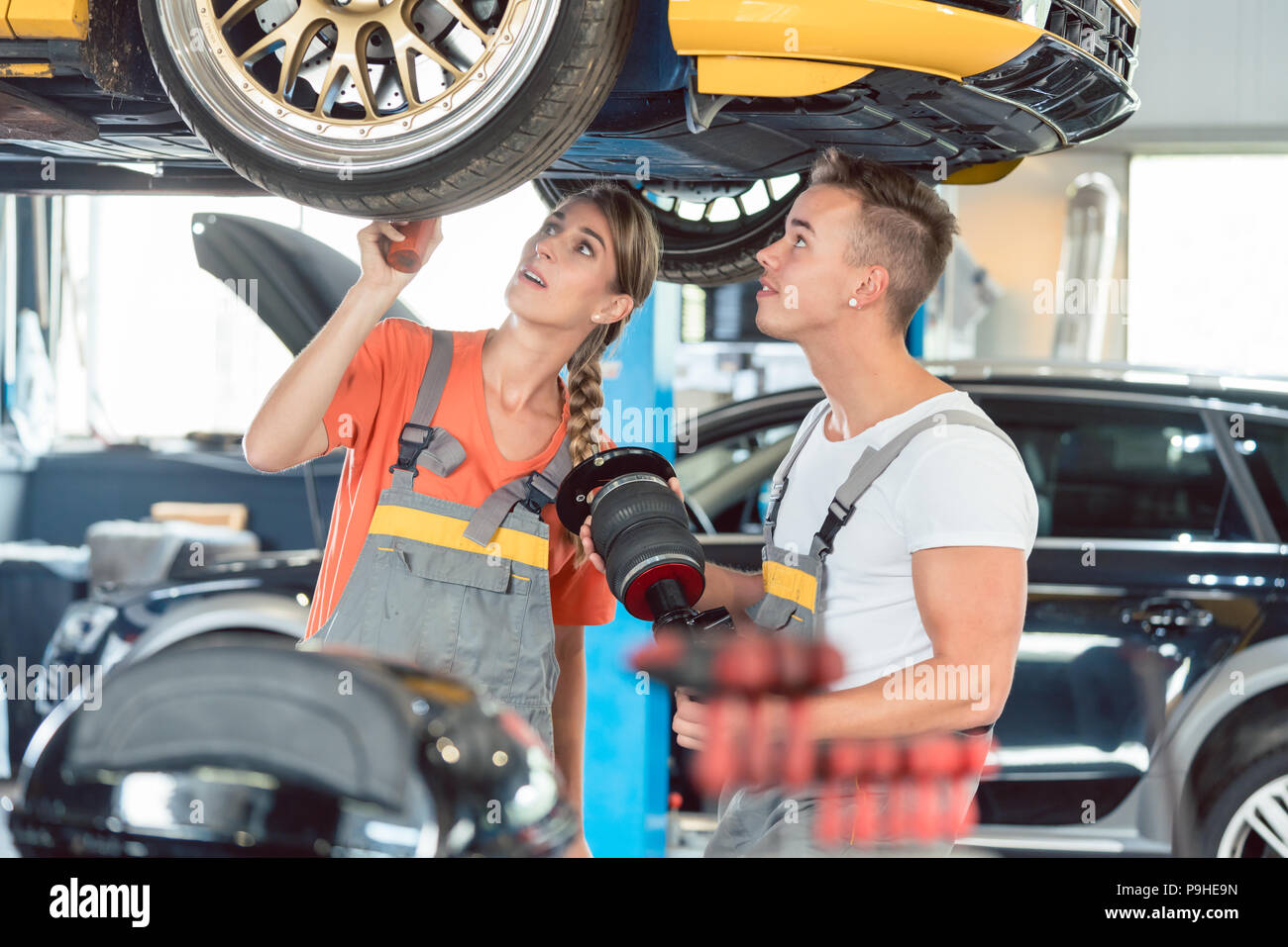 Experienced female auto mechanic with her colleague Stock Photo - Alamy