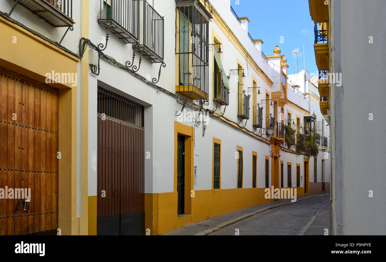 Typical narrow curving street with yellow and white painted ...