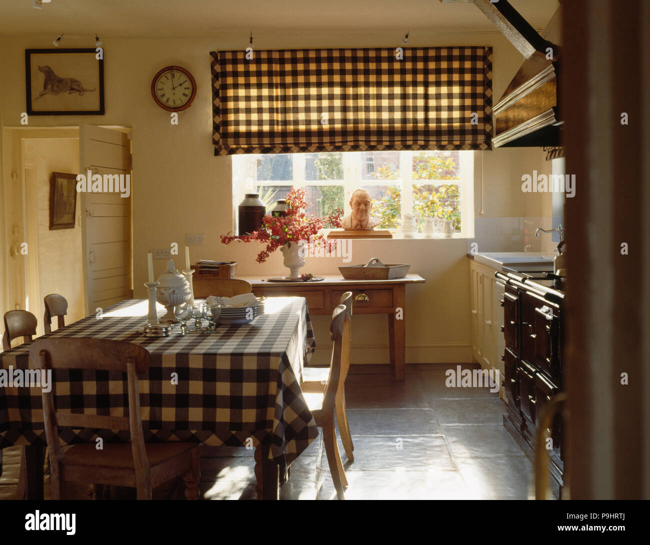 Checked blind and blue checked cloth on table in country kitchen with ...