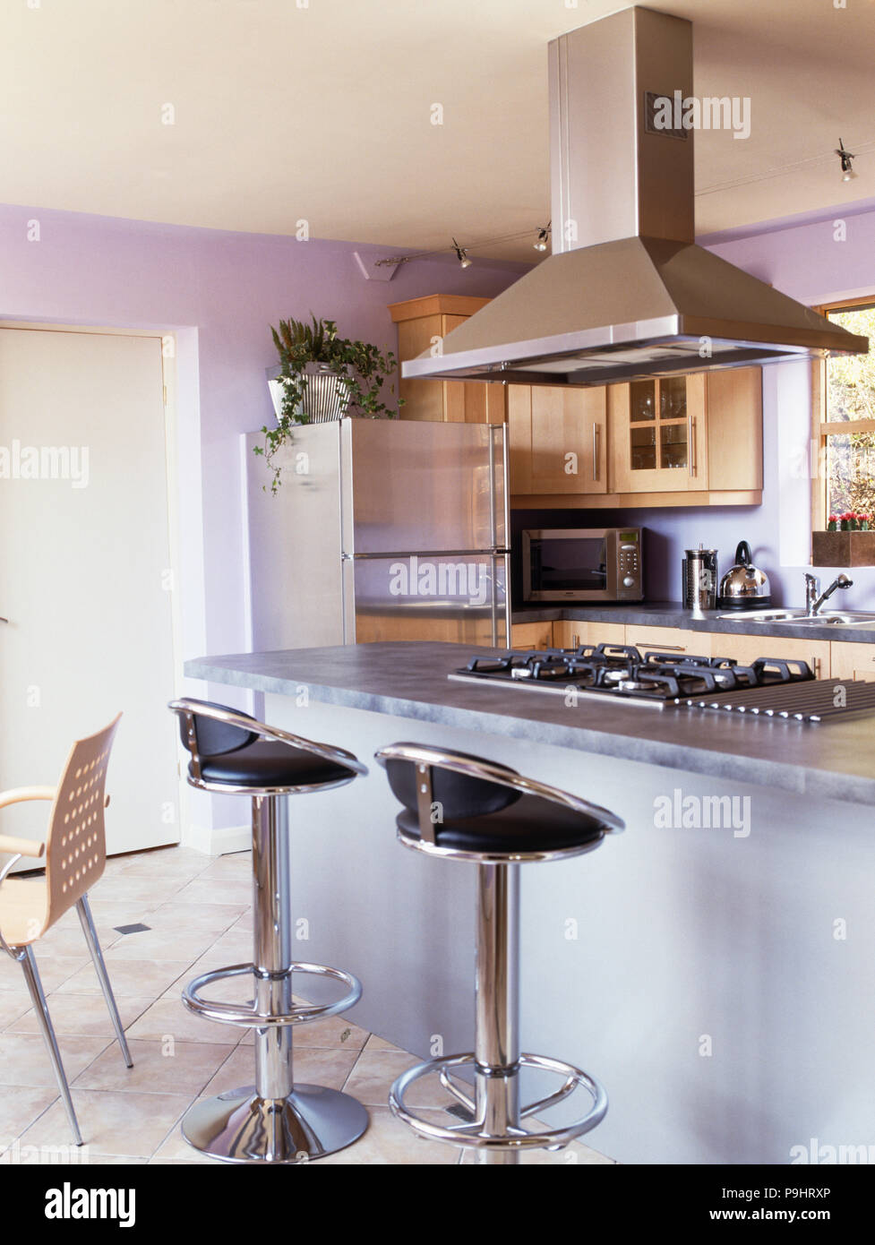 Chrome and leather stools at breakfast bar on island unit with ...